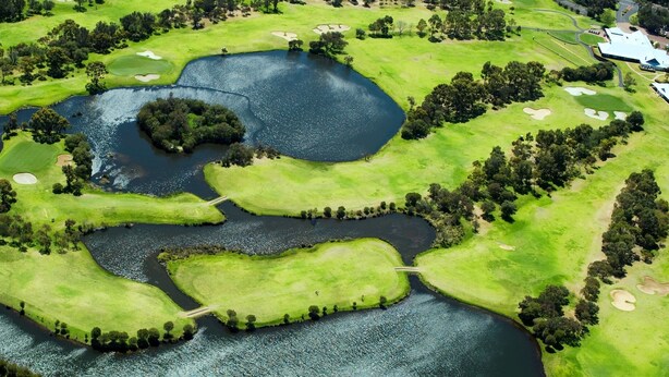 Vista aérea de um campo de golfe com vários lagos e armadilhas de areia.