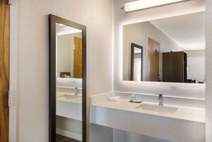 Casa de banho moderna com duas pias, um espelho grande e um porta-toalhas.