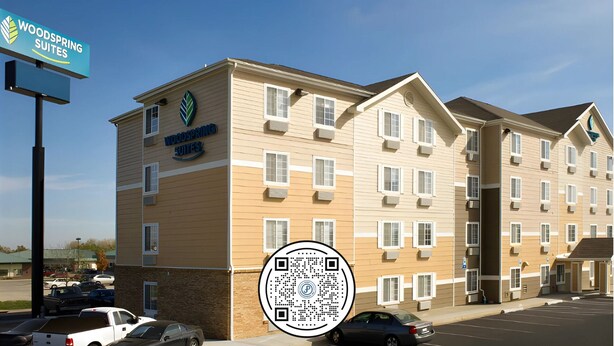 Um hotel de vários andares com uma placa indicando "Woodspring Suites".