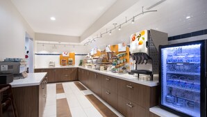 Cozinha moderna com máquina de café, refrigerador e diversos alimentos sobre o balcão.