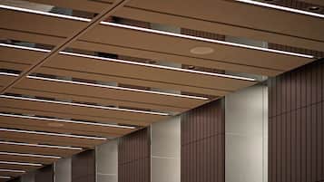 Um interior moderno com design de teto linear e painéis verticais de madeira.