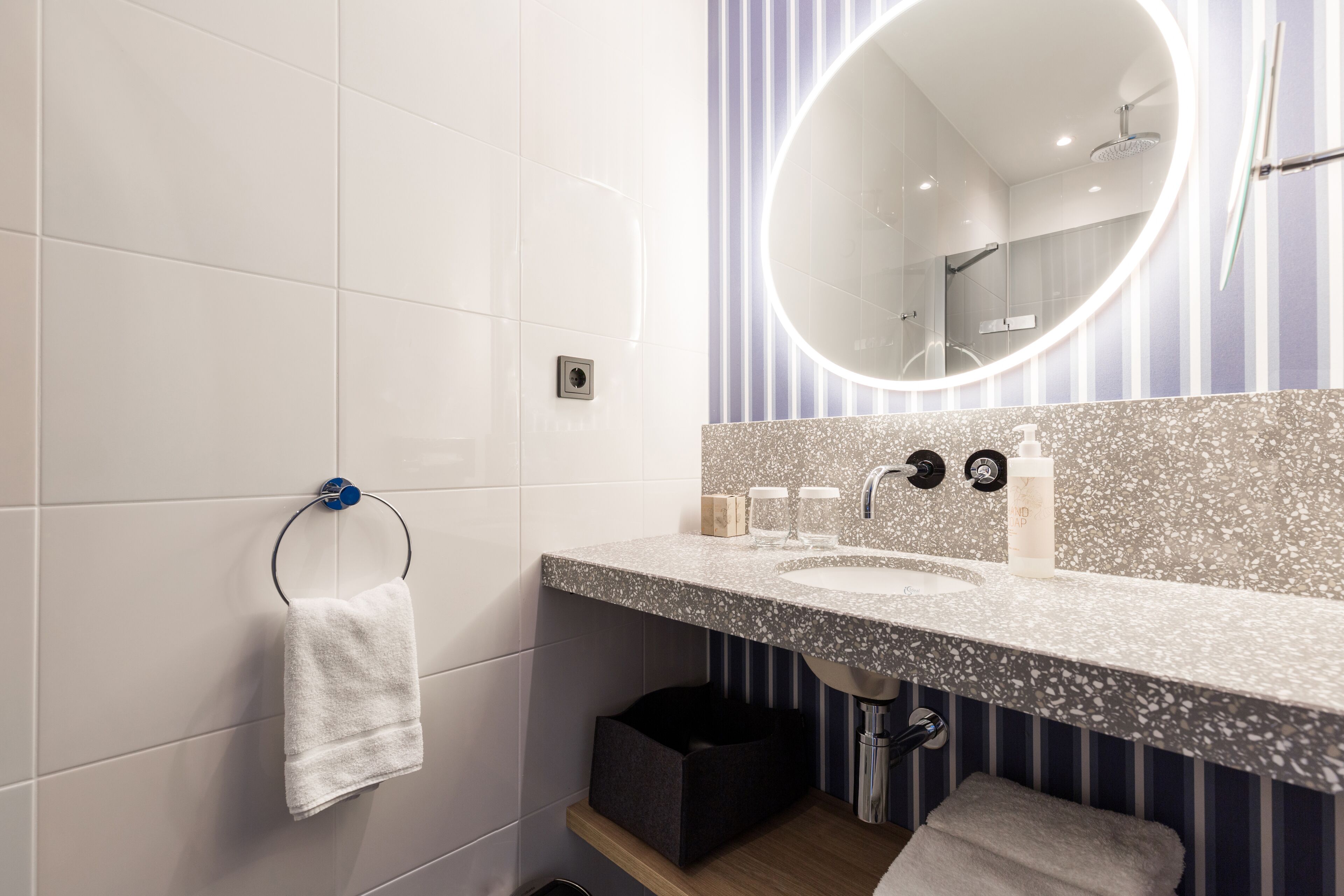 Uma casa de banho moderna com um espelho grande, duas lavatórios e um porta-toalhas.