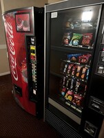 Máquina de vendas com logotipo Coca-Cola e variedade de lanches.