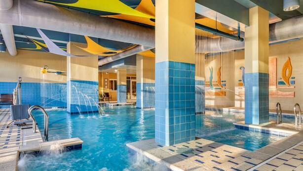 Piscina interna com azulejos azuis e design moderno.