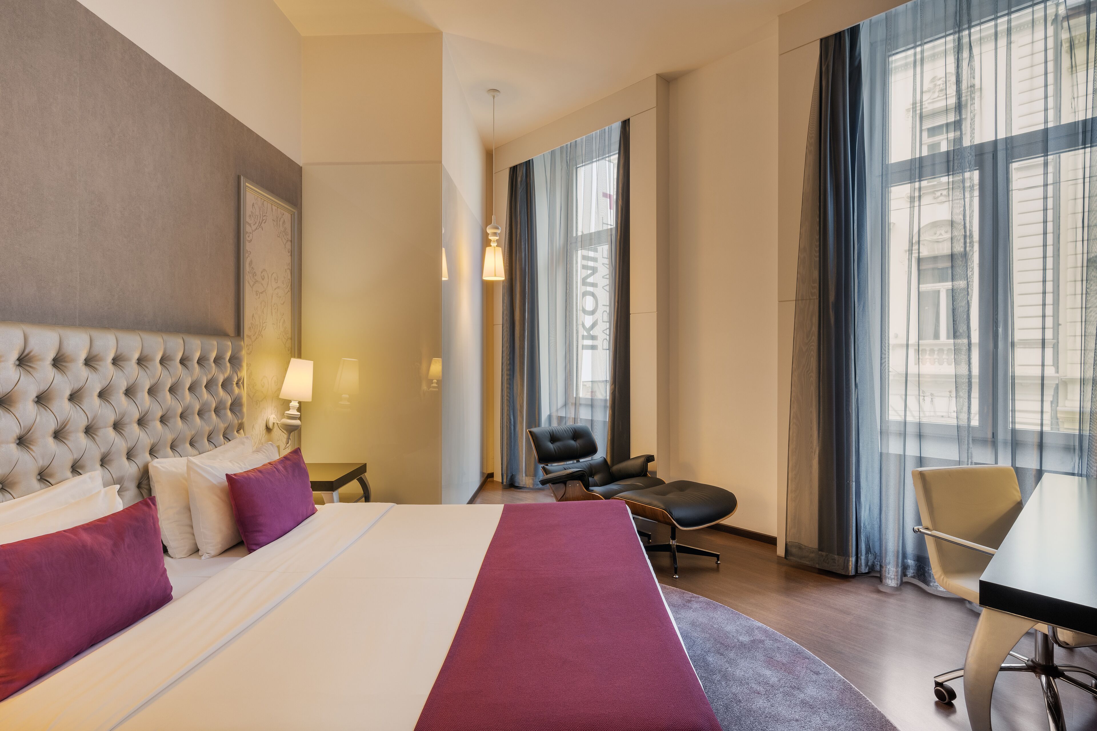 Quarto de hotel com uma cama grande, uma mesa e uma cadeira.