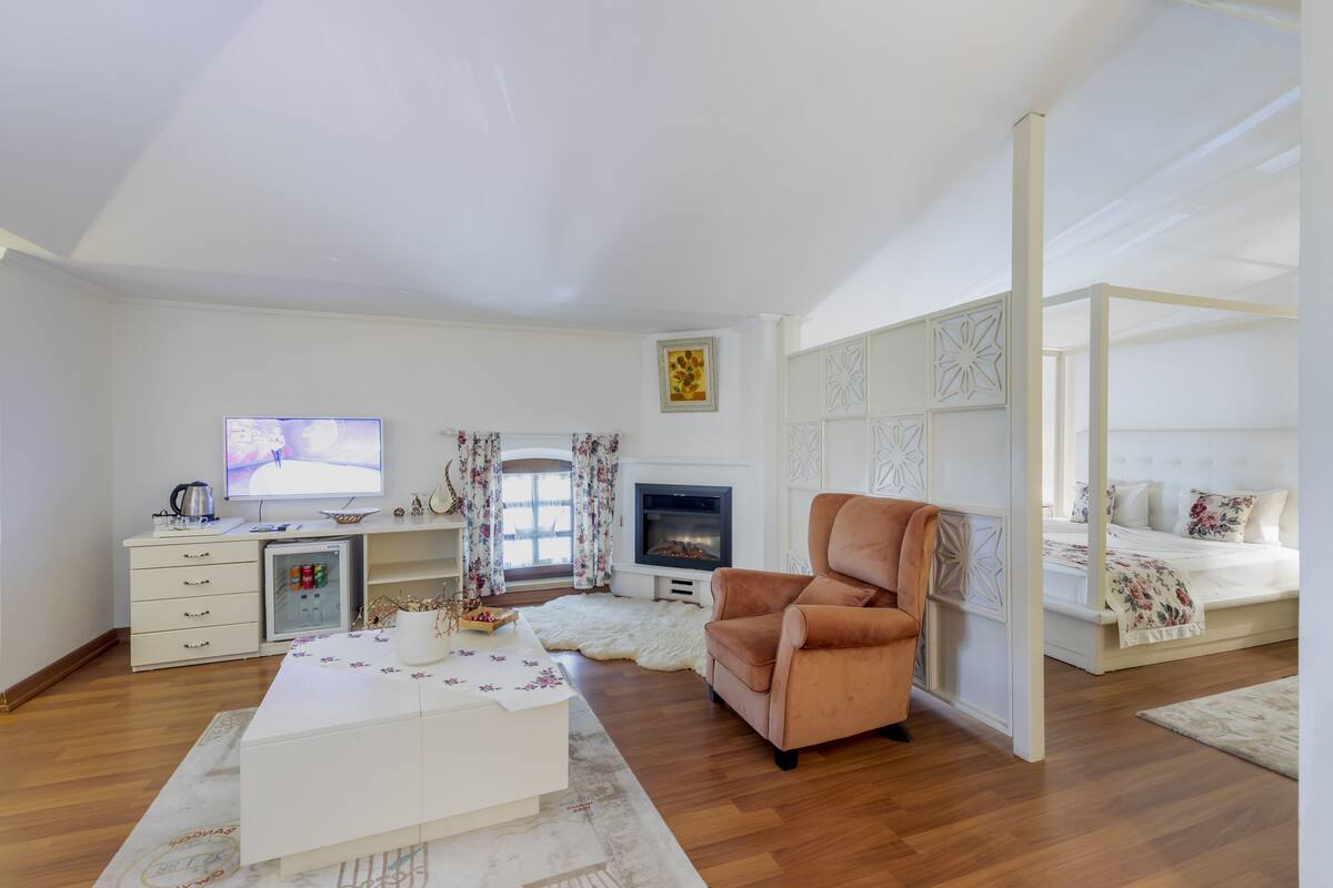 Uma sala de estar moderna com televisão, sofá e lareira.