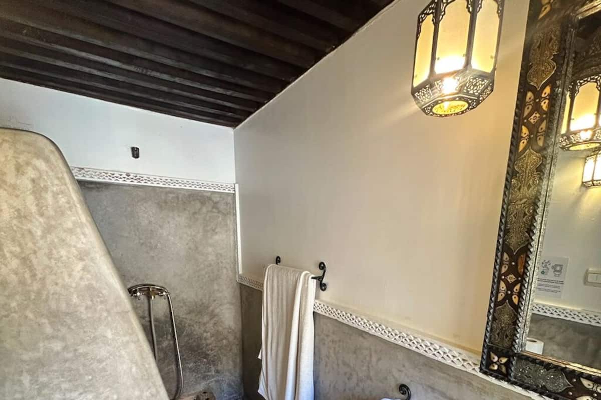 Uma casa de banho com sanita, lavatório e chuveiro.