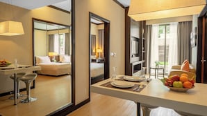 Quarto de hotel com área de refeições, uma cama e um espelho grande.