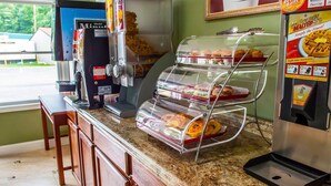 Um espaço com estação de café, máquina de café, vitrine com doces e uma placa indicando Better Batter.