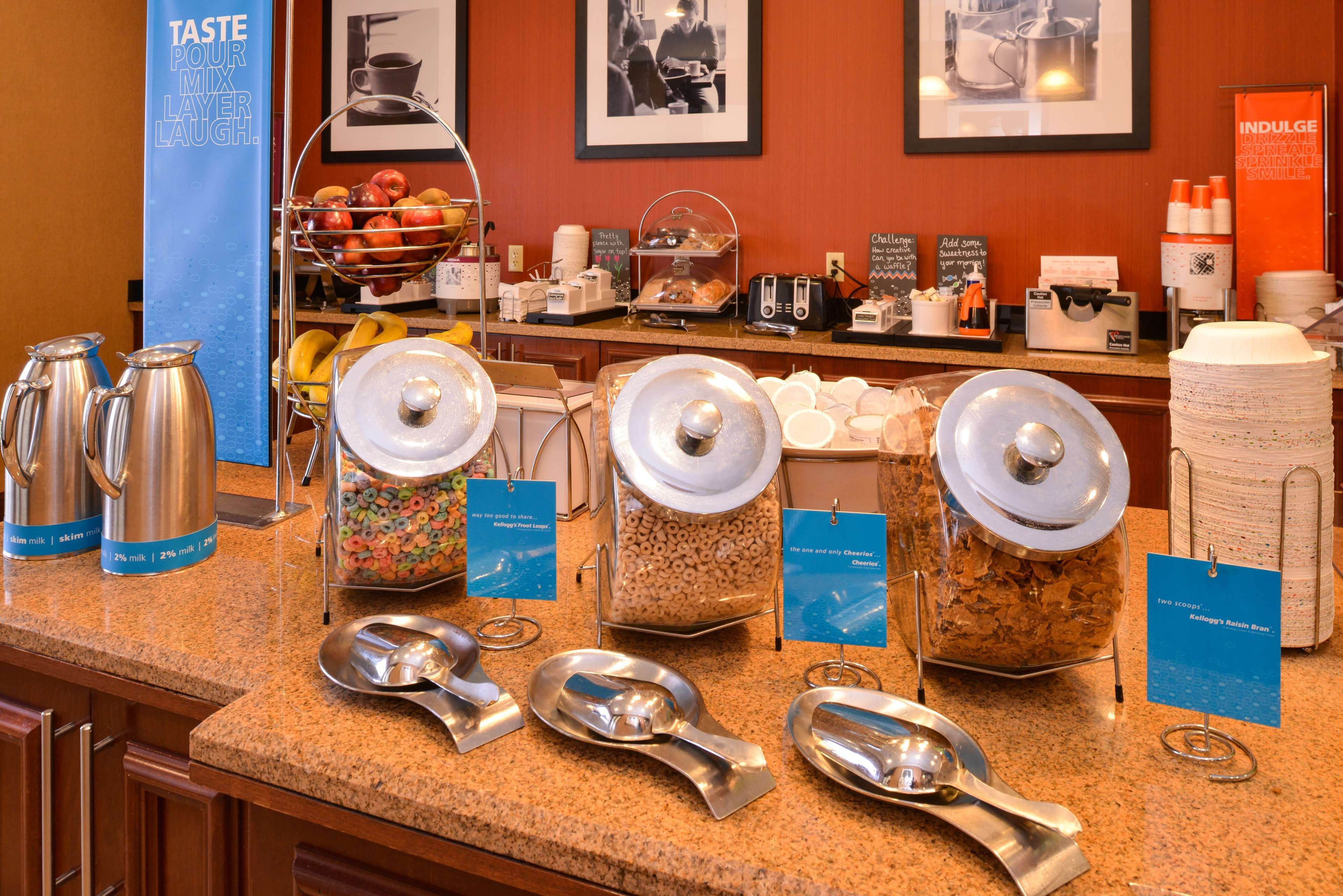 Uma área de buffet com diversas opções de comida e utensílios.