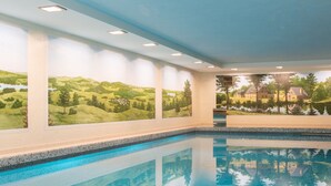 Piscina com um mural de paisagem na parede.