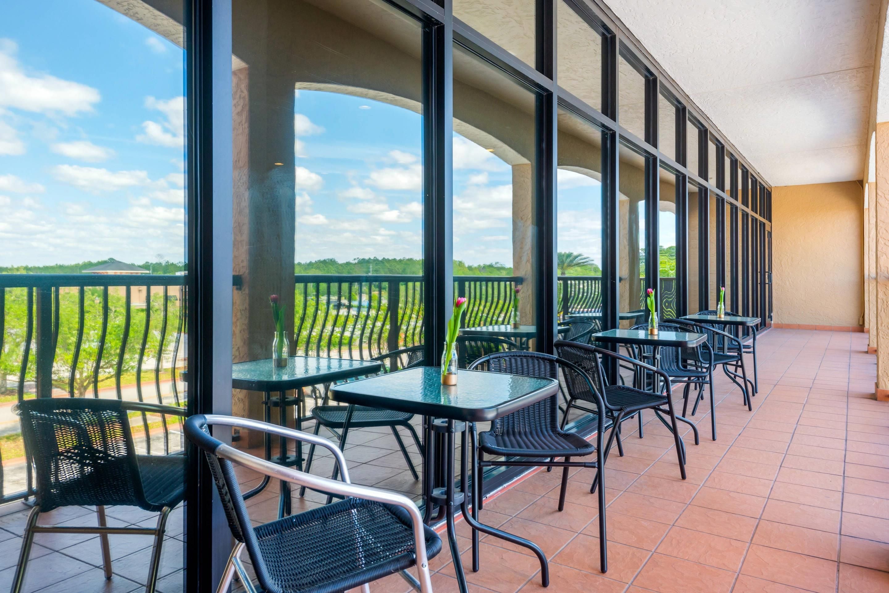 Terraço com área de estar ao ar livre, grandes janelas e vista para a paisagem.
