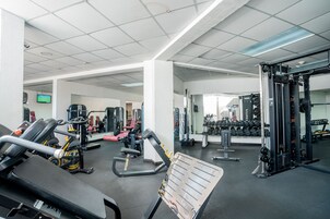 Uma academia com diversos equipamentos de exercícios, incluindo esteiras e aparelhos de musculação.