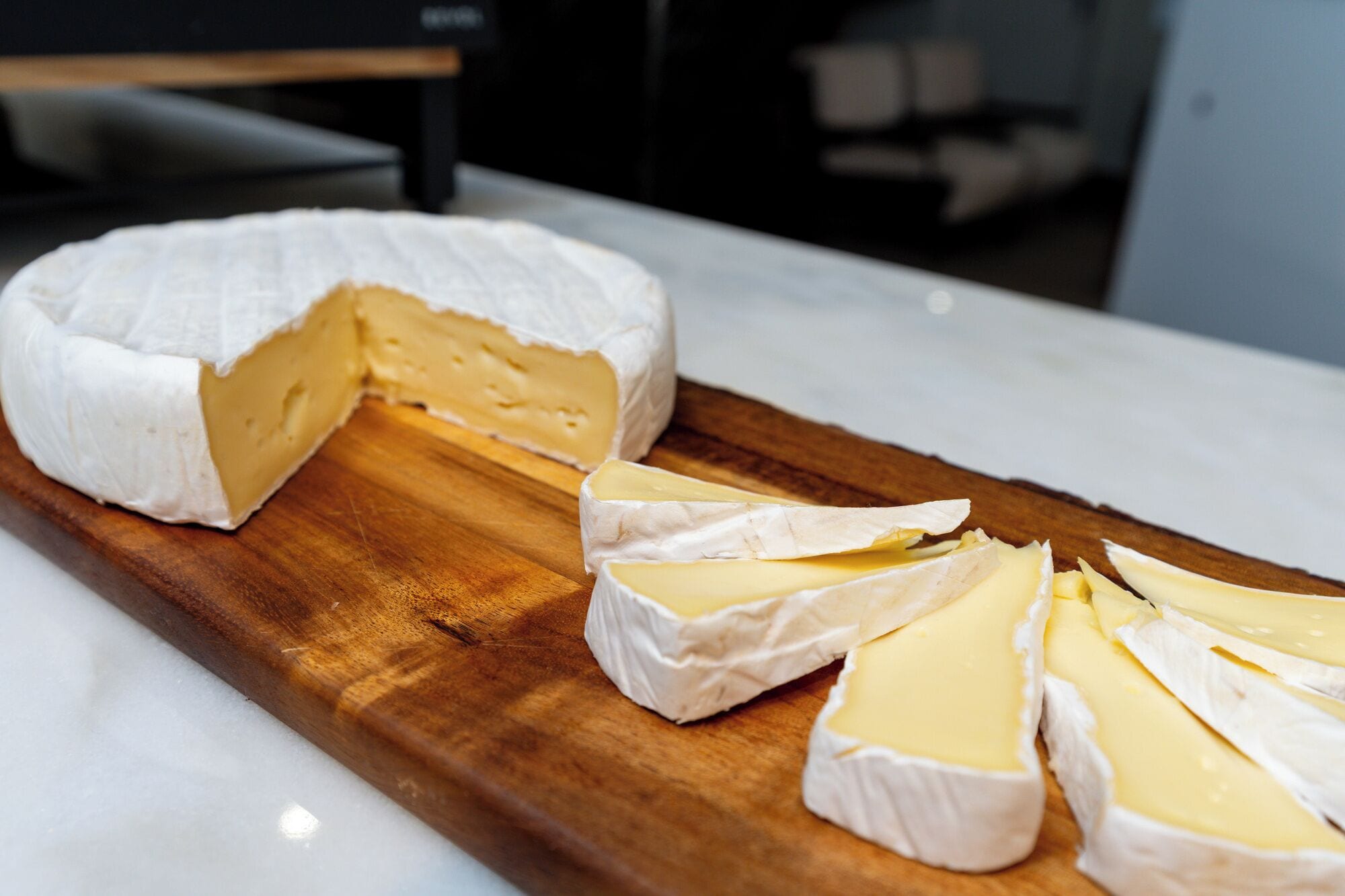 Um queijo sobre uma tábua de madeira.