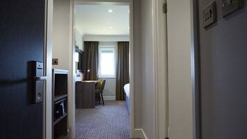 Quarto de hotel com cozinha compacta, escrivaninha e cama.