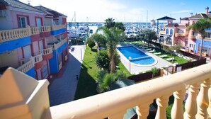 Uma marina com barcos, uma piscina e edifícios coloridos.
