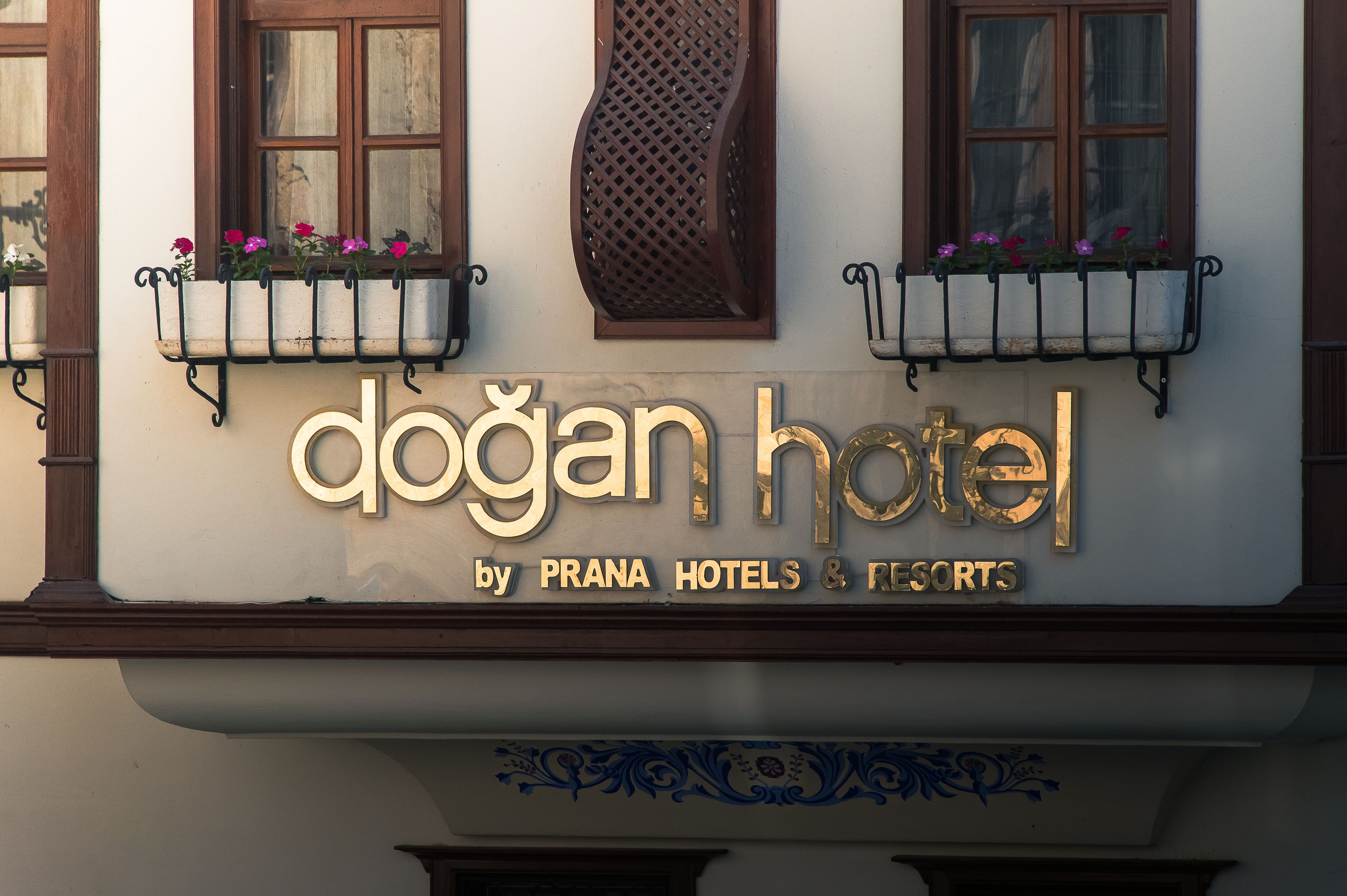 Um letreiro de hotel com o nome 'dogan hotel' e a inscrição 'by PRANA HOTELS & RESORTS'.