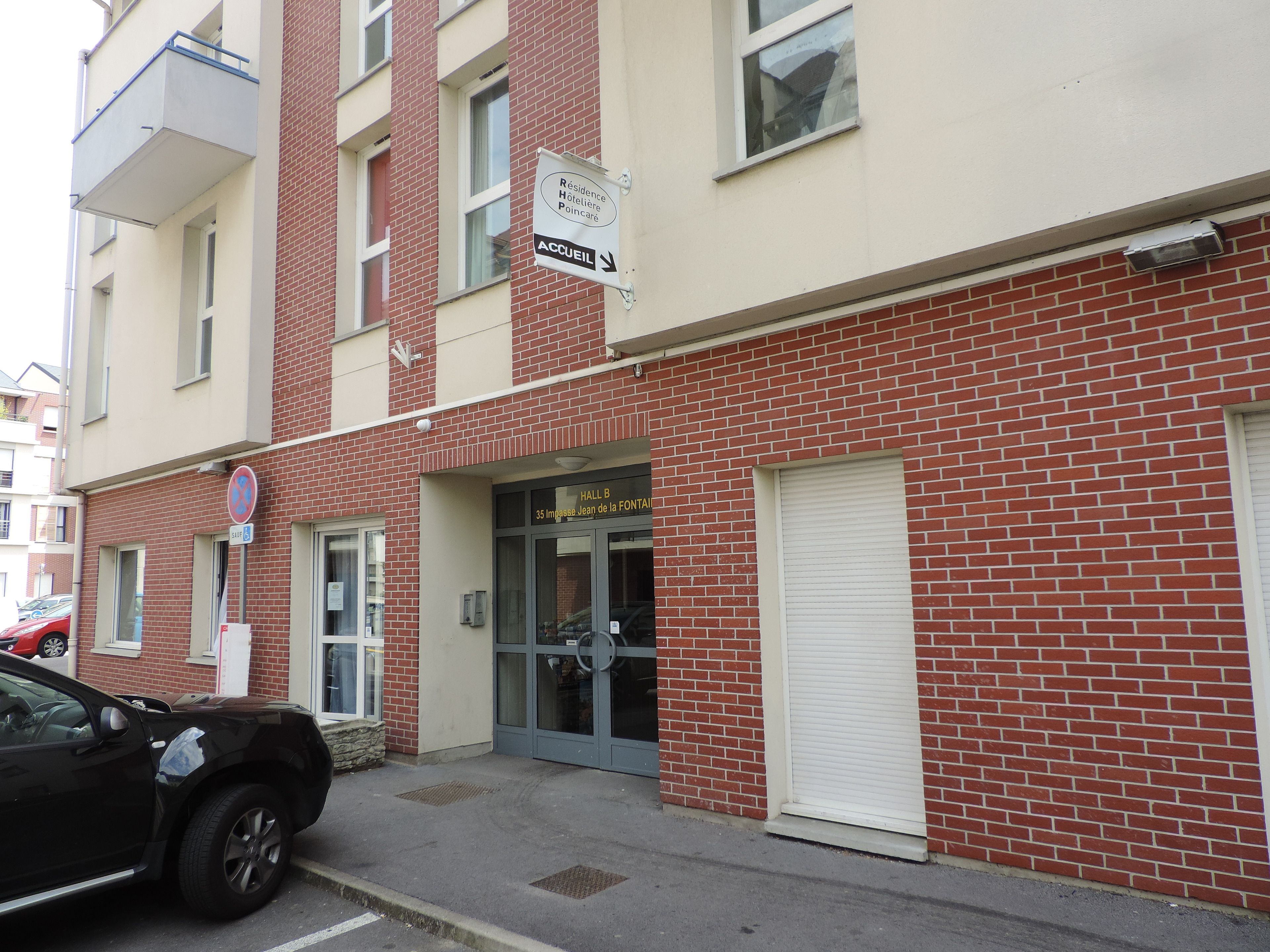 Entrada de hotel com uma placa indicando 'Residence Hôtelière Poincaré' e 'HALL B'.