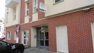 Entrada de hotel com uma placa indicando 'Residence Hôtelière Poincaré' e 'HALL B'.