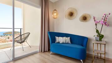 Uma sala de estar moderna com um sofá azul, uma cadeira preta e uma pequena mesa com uma planta.
