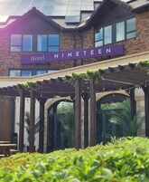 Entrada de hotel com uma placa que diz "Hotel Nineteen".