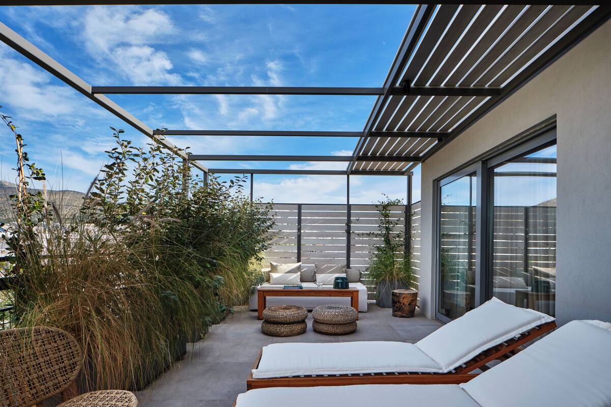 Terraço no telhado com pérgola, área de estar externa e vista da paisagem urbana.