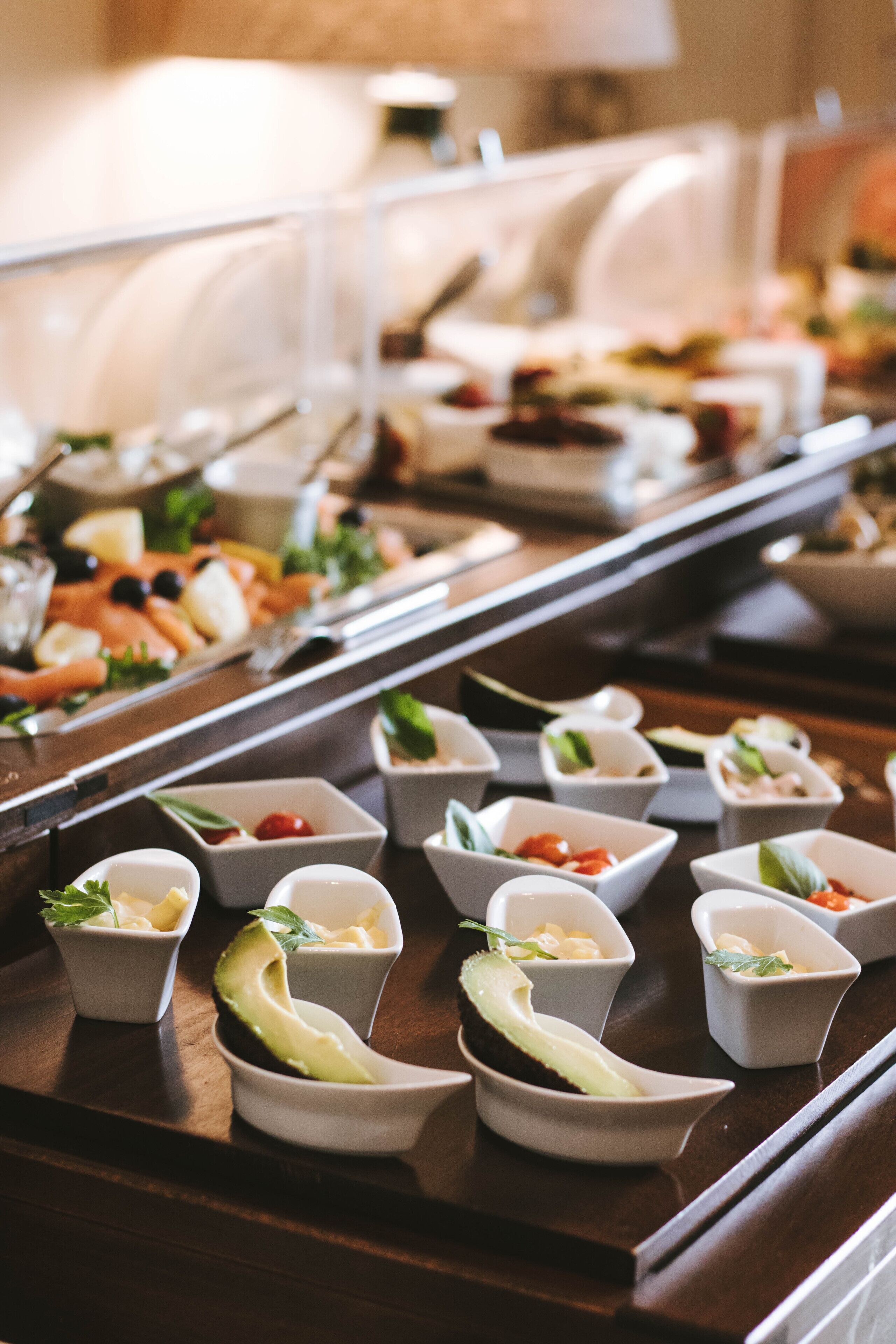 Um buffet com diversos pratos e pequenas porções de comida.