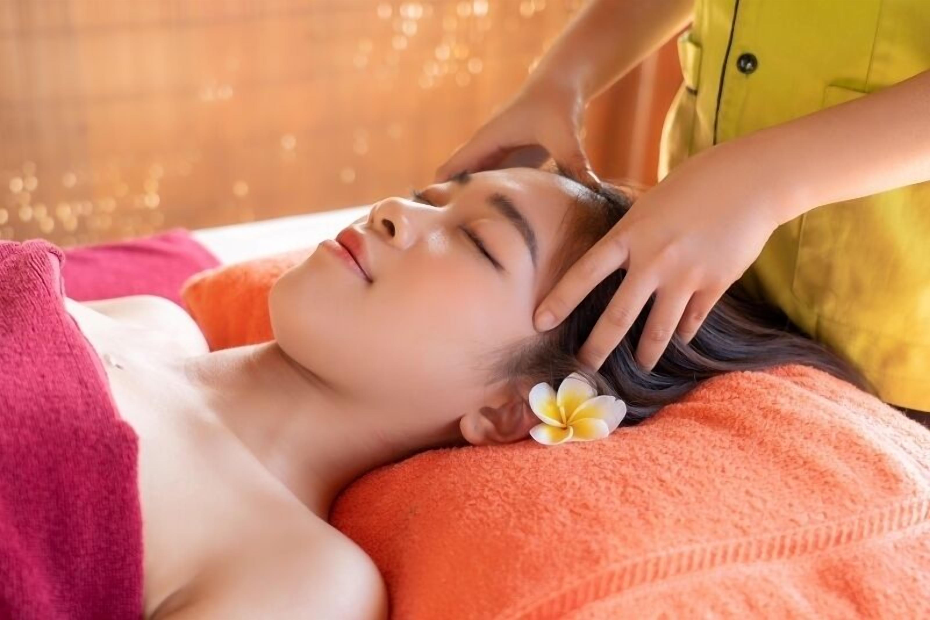 Uma pessoa recebendo massagem na cabeça em um spa.