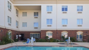 Um hotel com piscina, várias janelas e fachada de tijolos.