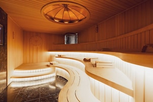 Interior de madeira com bancos curvos e uma luminária circular central.