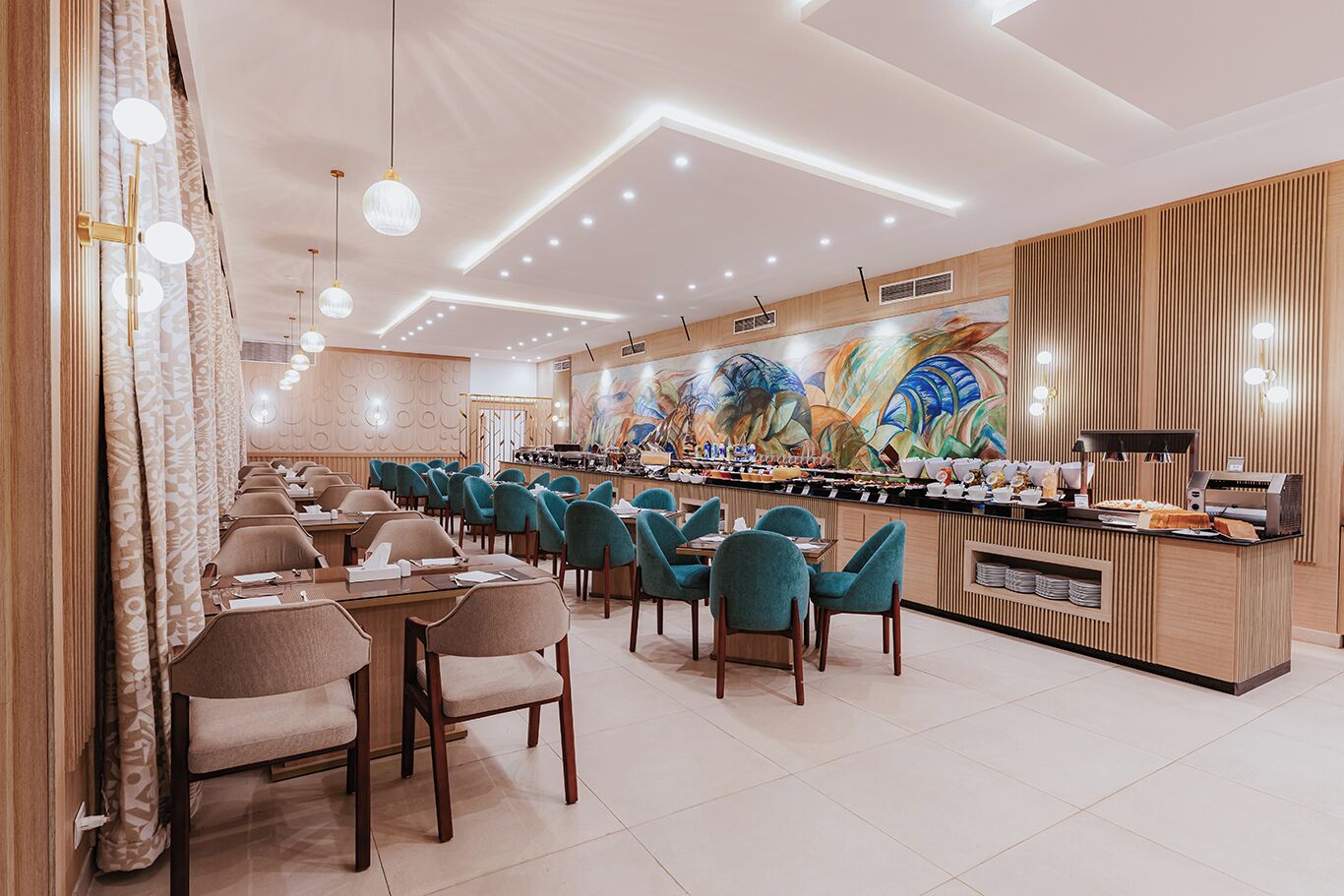 Um restaurante moderno com um balcão extenso, cadeiras cor de azul-turquesa e um mural na parede.