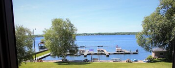 Vista para o lago com barcos atracados, um gazebo e área para piquenique.