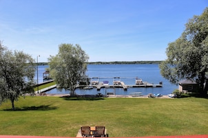 Vista para o lago com um píer, barcos e um gazebo.