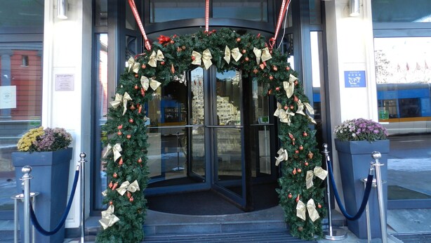 A entrada do Hotel Central com uma guirlanda natalina e enfeites de laço.