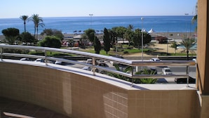 Varanda com vista para a praia e estacionamento.