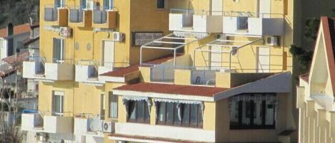 Um hotel com vários andares, varandas e aparelhos de ar condicionado.
