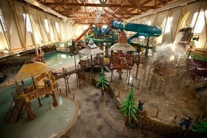 Parque aquático em ambiente fechado com toboáguas, piscina e áreas de recreação.