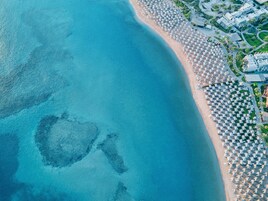 Perto da praia, espreguiçadeiras, guarda-sóis, toalhas de praia