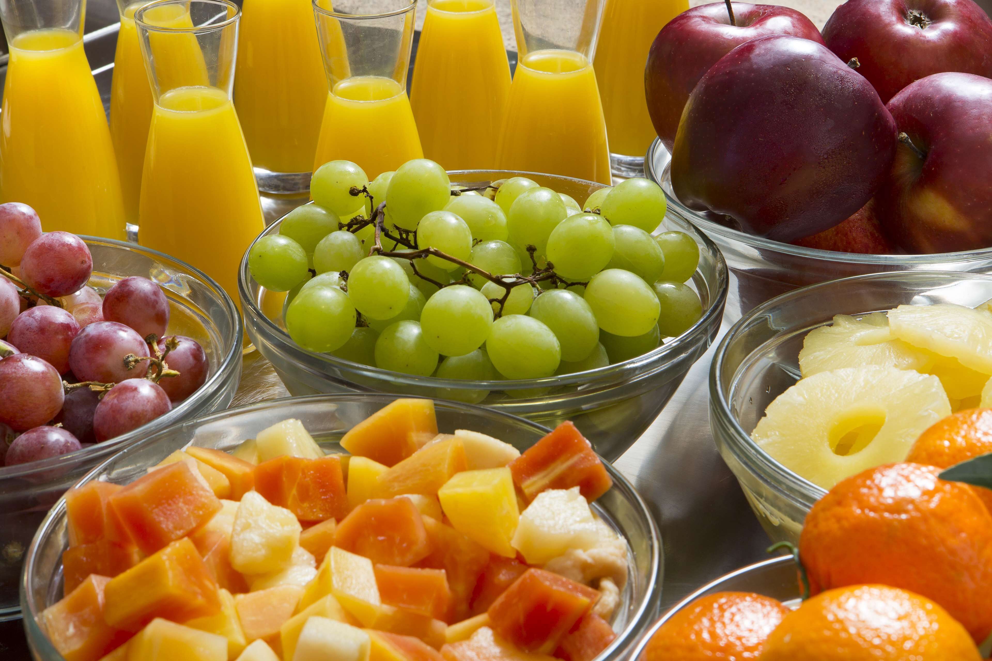 Diversas frutas e sucos sobre uma mesa.