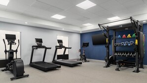 Academia com esteiras, bicicleta ergométrica e área para musculação.