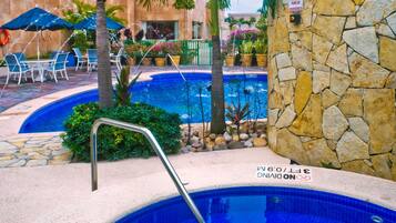 Piscina com muro de pedra e placa indicando área sem saltos.