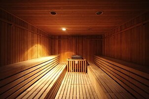 Uma sauna com bancos de madeira e um banco central.