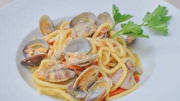 Um prato de massa com amêijoas e salsa picada.