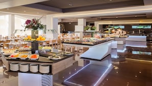 Espaço de buffet com diversos alimentos e um arranjo floral central.