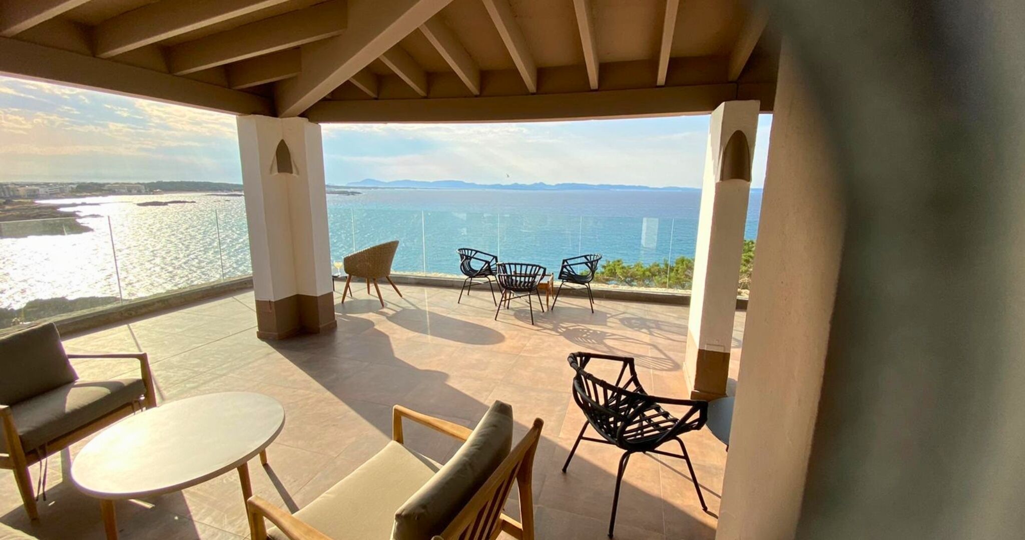 Uma área de estar coberta ao ar livre com vista para o mar.