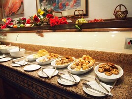 Buffet com diversos alimentos e utensílios dispostos sobre um balcão.