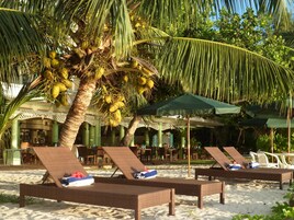 Na praia, praia de areia branca, guarda-sóis de praia, toalhas de praia 