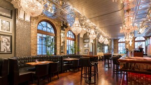 Restaurante com assentos de couro, mesas de madeira e balcão.