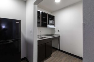 Um frigorífico/congelador grande, um micro-ondas, uma placa de cozinha 