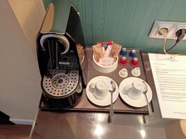 Quarto de hotel com minibar, telefone, mesa de apoio e menu.